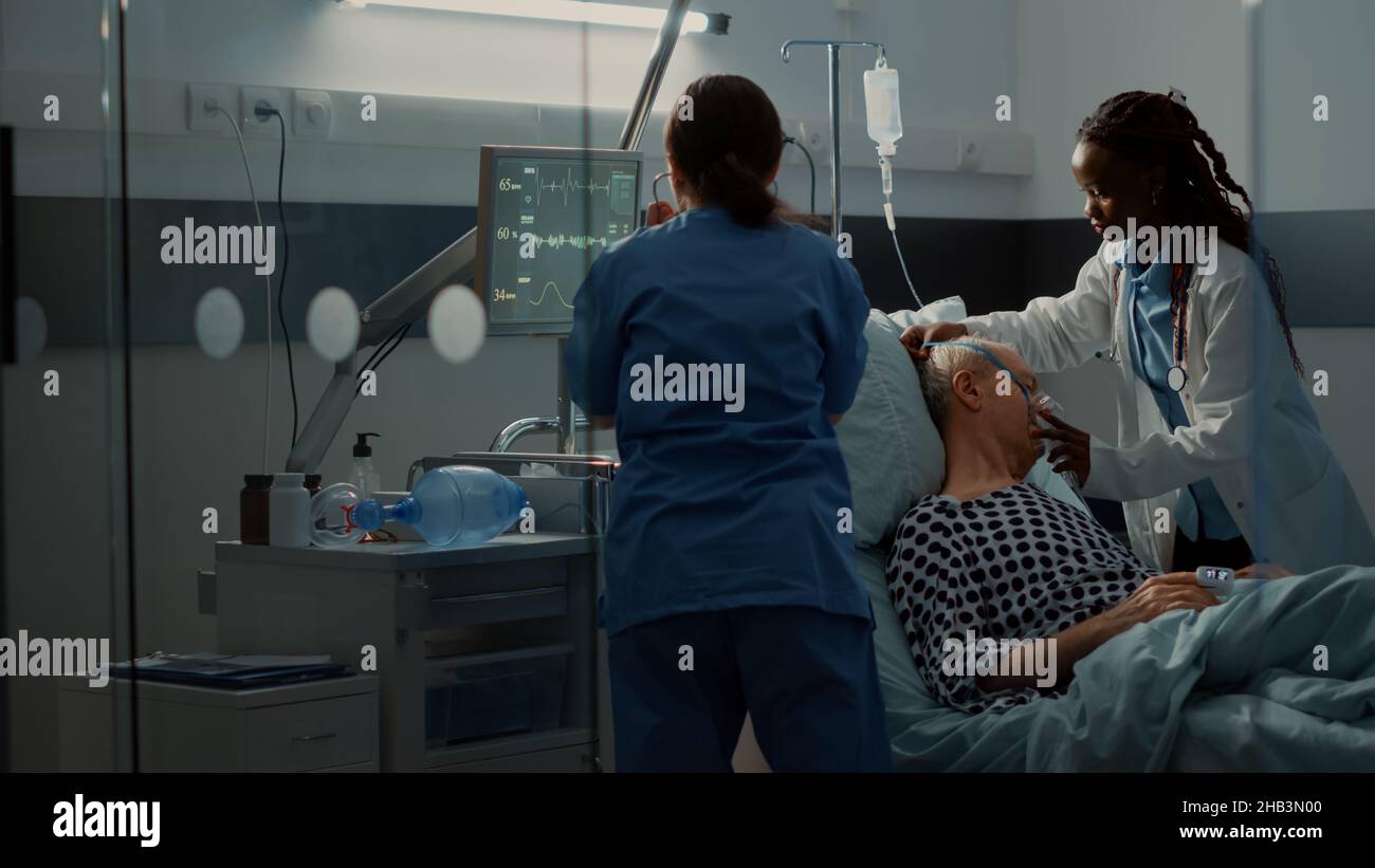 Nurse and african american medic using oxygen tube and pulse rate ...