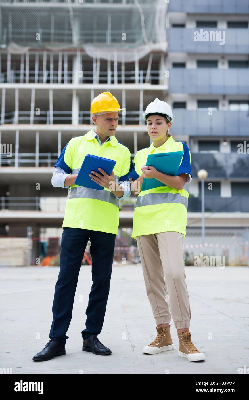 Two builders planning their work in construction plant Stock Photo - Alamy