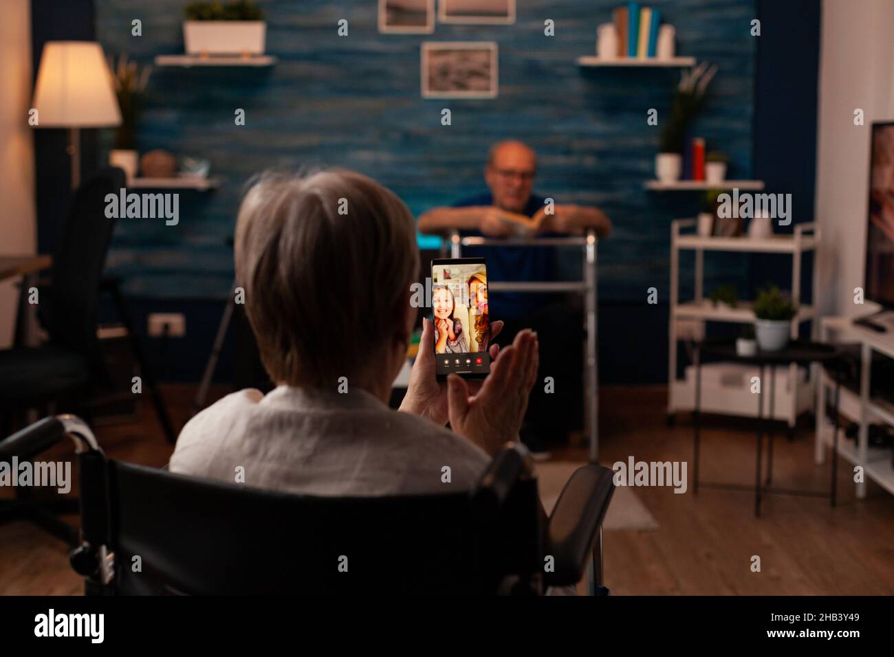Aged person with disability using video call on smartphone for online ...