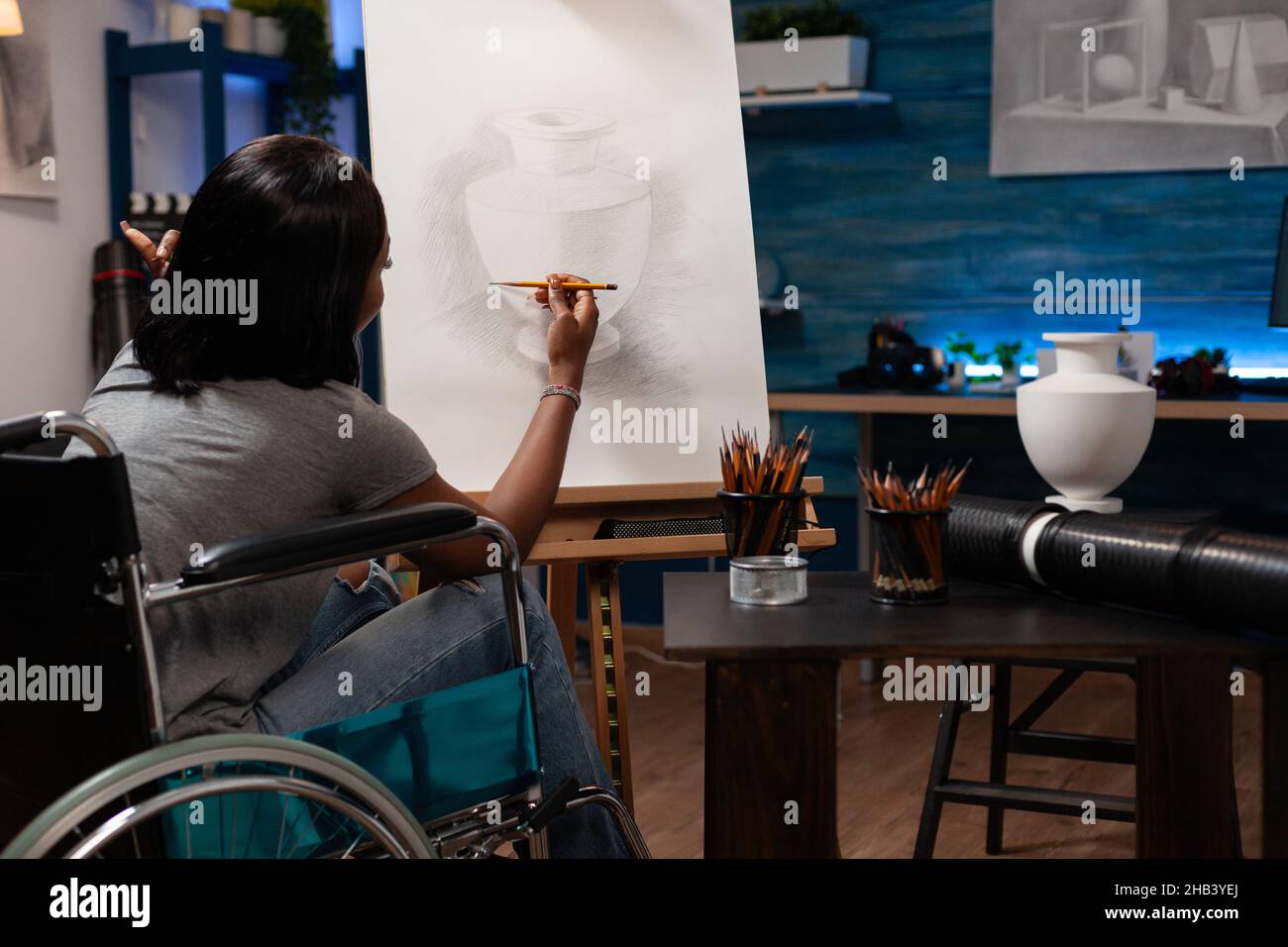 Art student in wheelchair sketching vase on canvas working at artistic ...