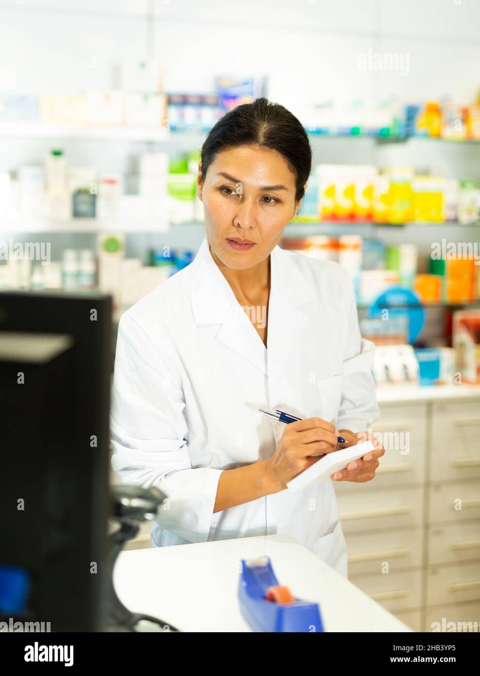 Female doctor standing at counter and writing Stock Photo - Alamy