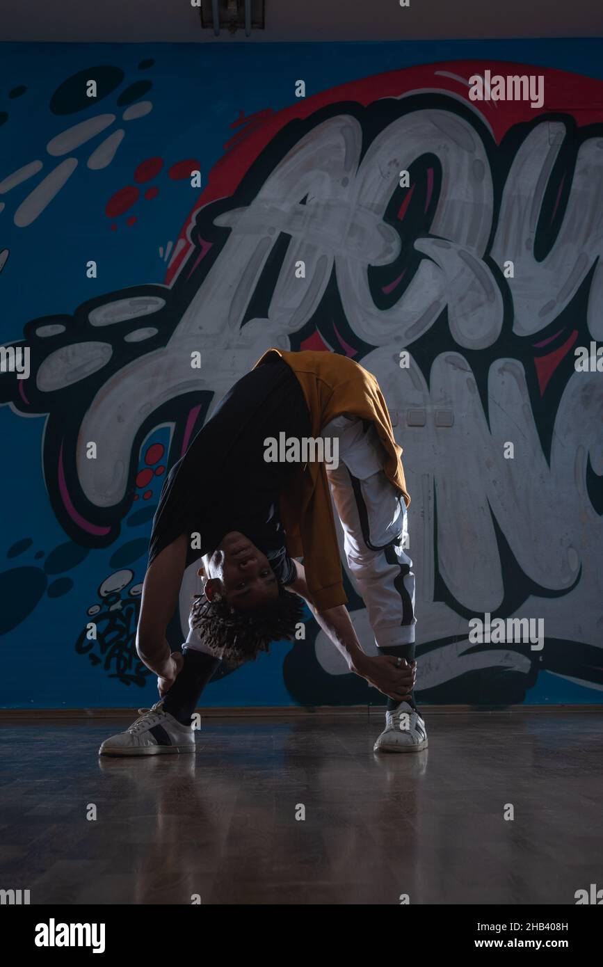 African American hip hop dancer (breakdancer) performing over graffiti ...