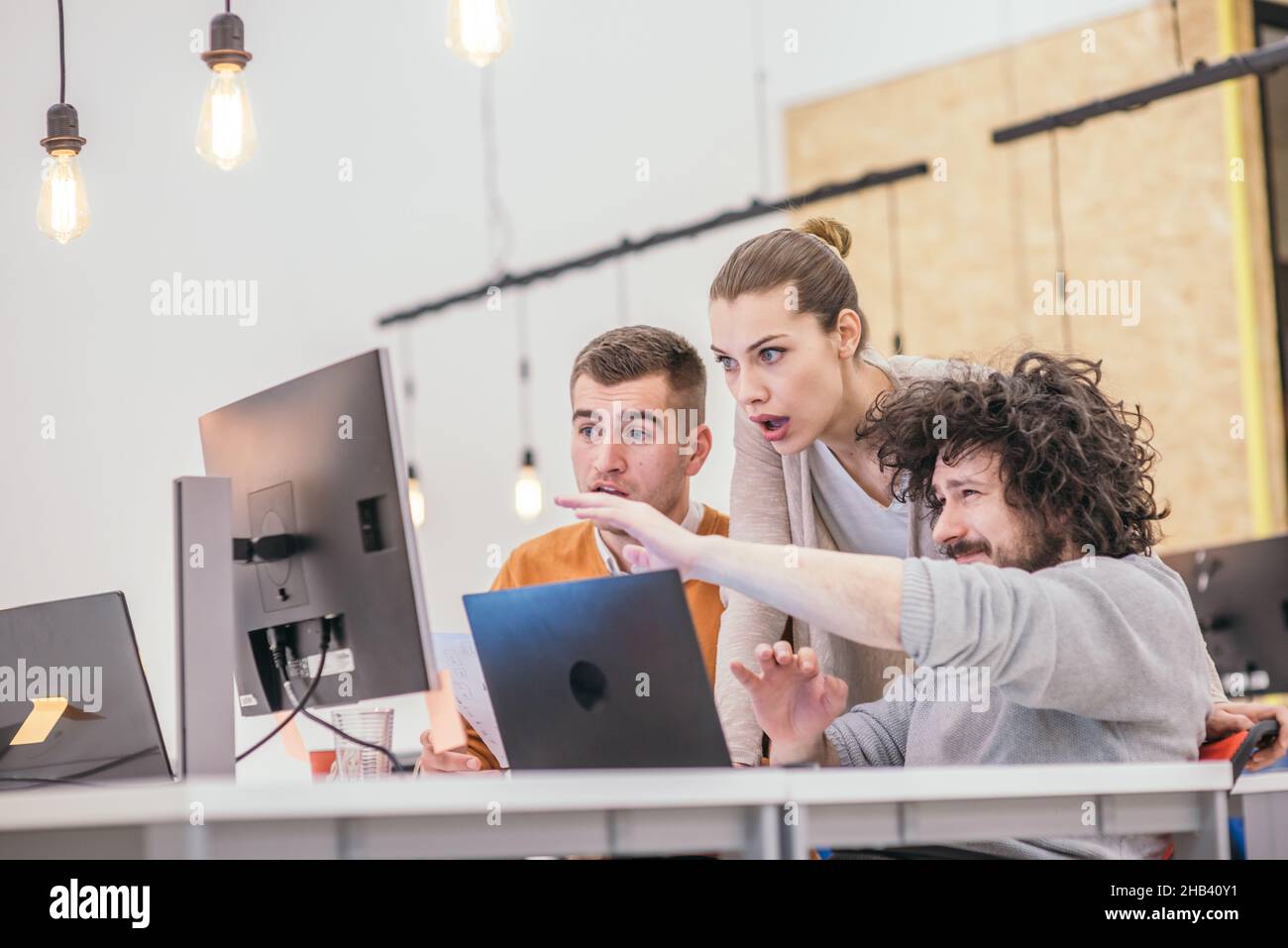 Happy surprise for the teammates. Coworkers cheering while looking at a ...