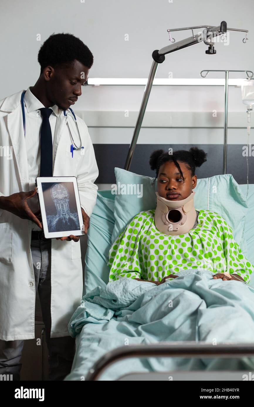 African american sick patient wearing neck cervical collar lying in bed ...
