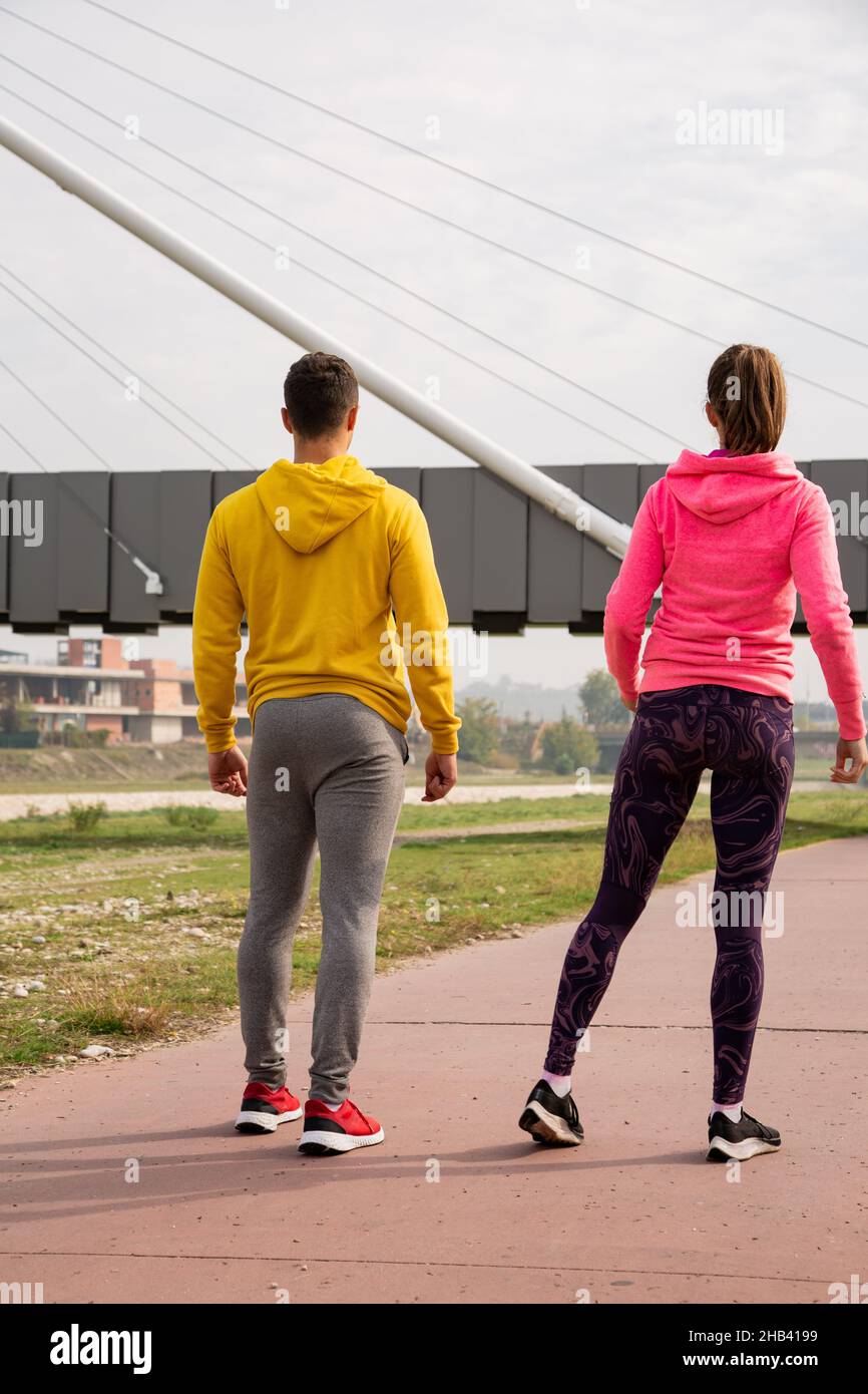 Amazing and attractive strong couple is standing on the running track ...