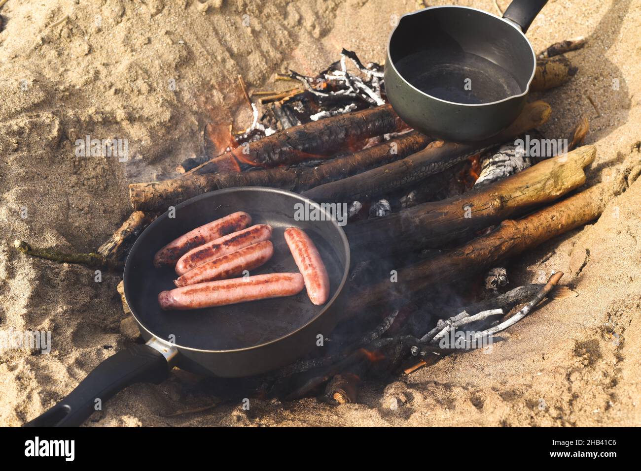 Cooking food outside on an open fire as a bbq on a sandy beach Stock ...