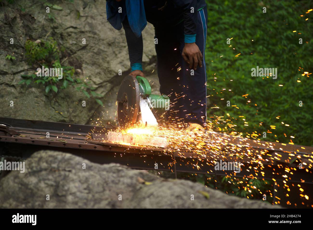 A professional craftsman is cutting metal with a rotatable diamond ...