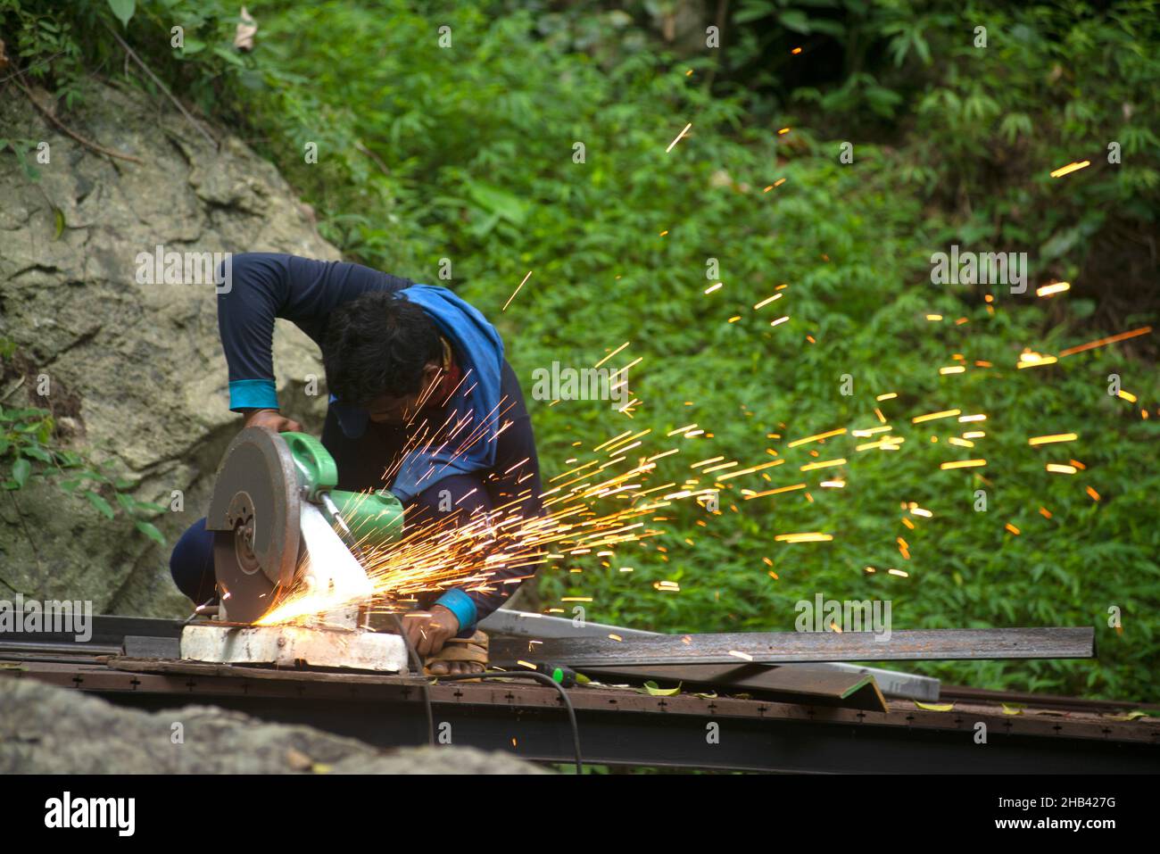 A professional craftsman is cutting metal with a rotatable diamond ...