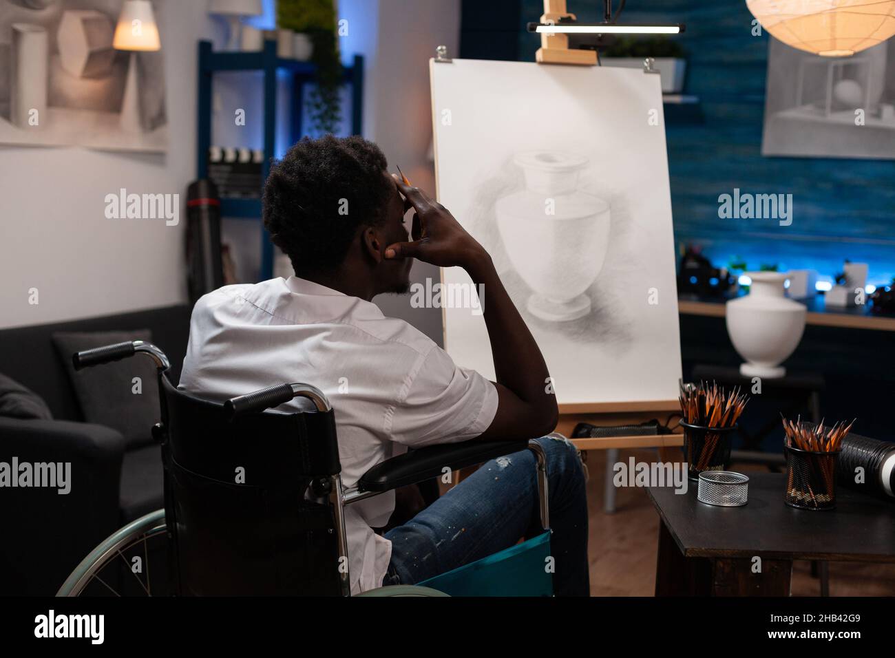 Illustrator student in wheelchair drawing vase illustration on canvas ...