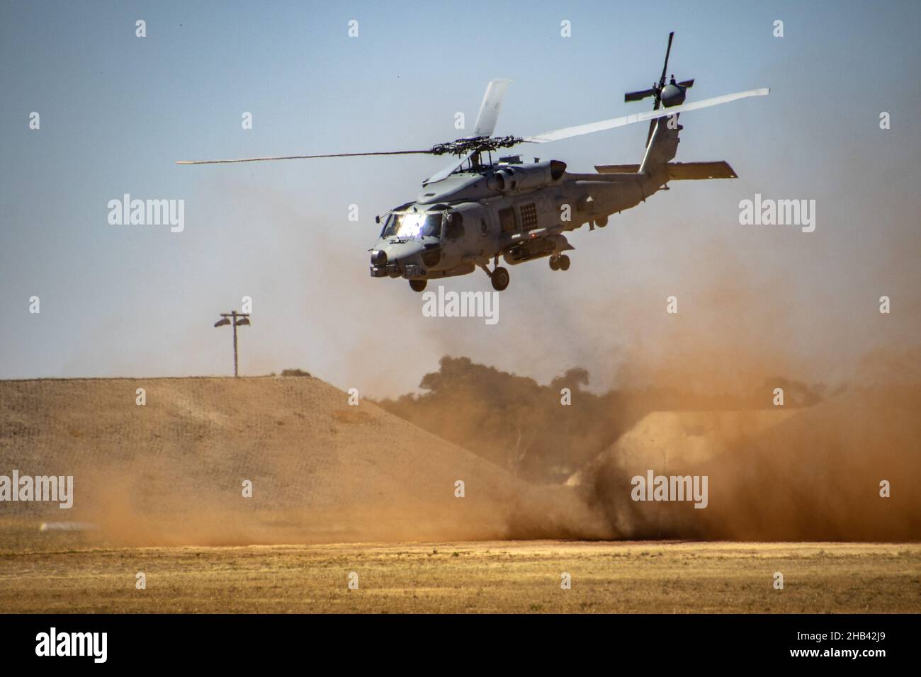 Helicopter flying up and splashing sand Stock Photo - Alamy
