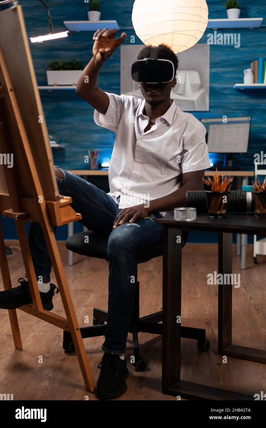 Young artist wearing virtual reality goggles imagining draw masterpiece ...