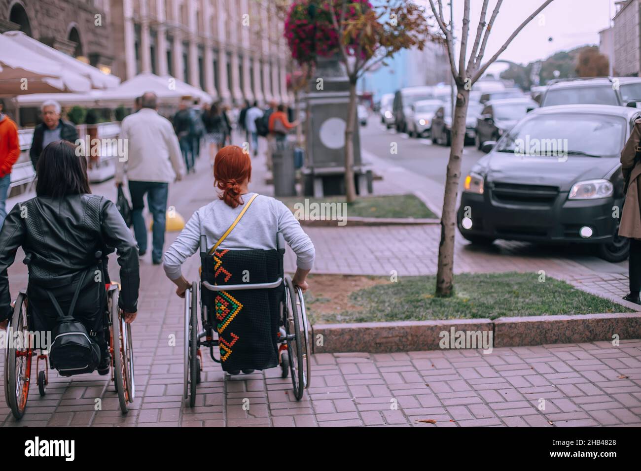 Two friends in wheelchairs in town on the sidewalk. Inconvenience for ...
