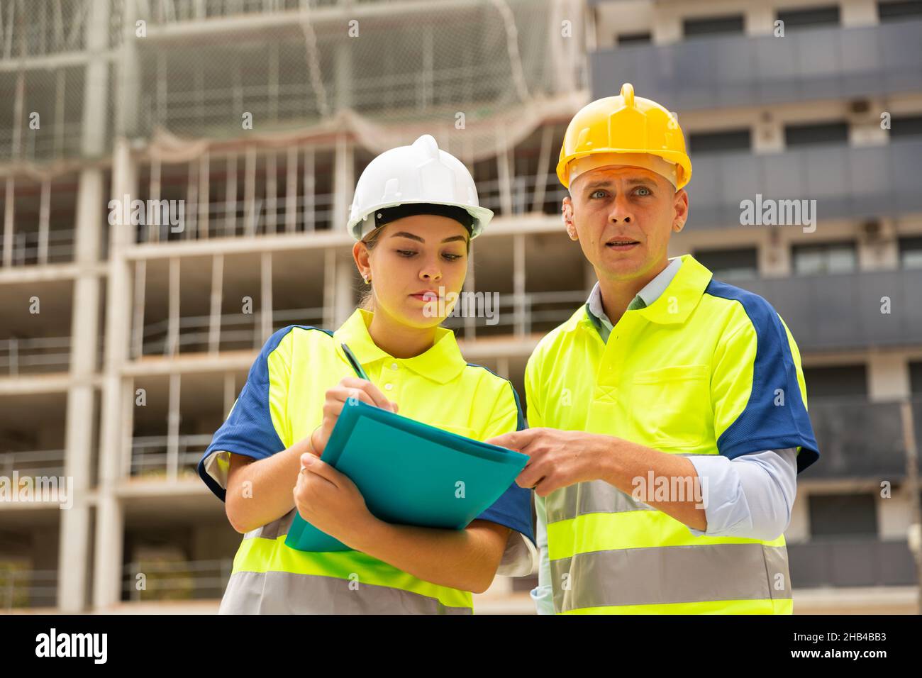 Civil engineers checking work process in construction site Stock Photo ...
