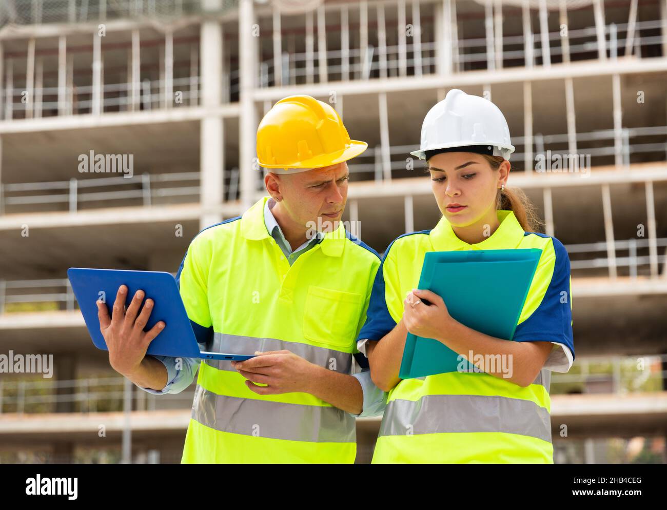 Two builders planning their work in construction plant Stock Photo - Alamy