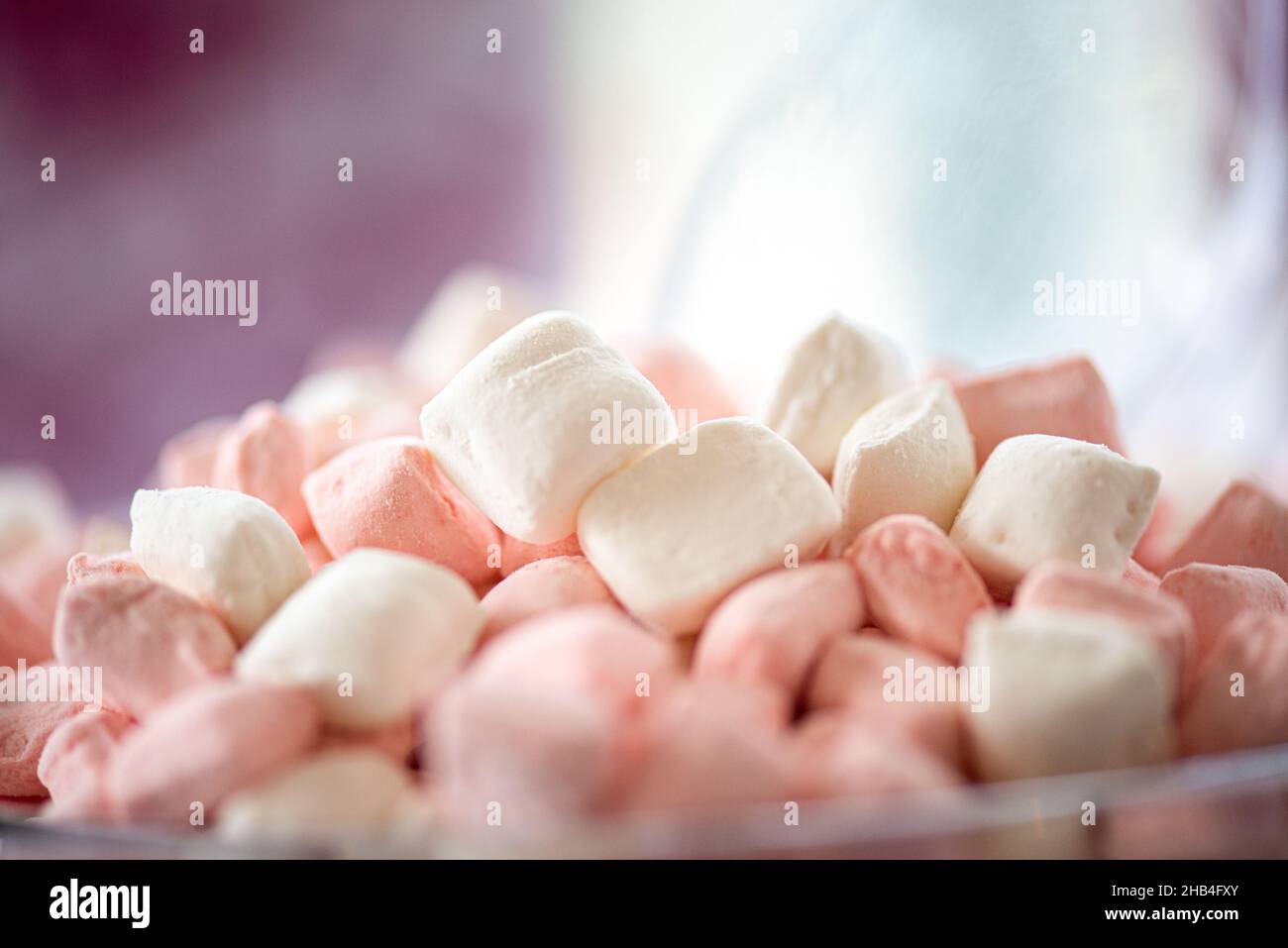 Glass bpwl filled with delicious pink and white puffy mints at wedding ceremony desert bar Stock ...