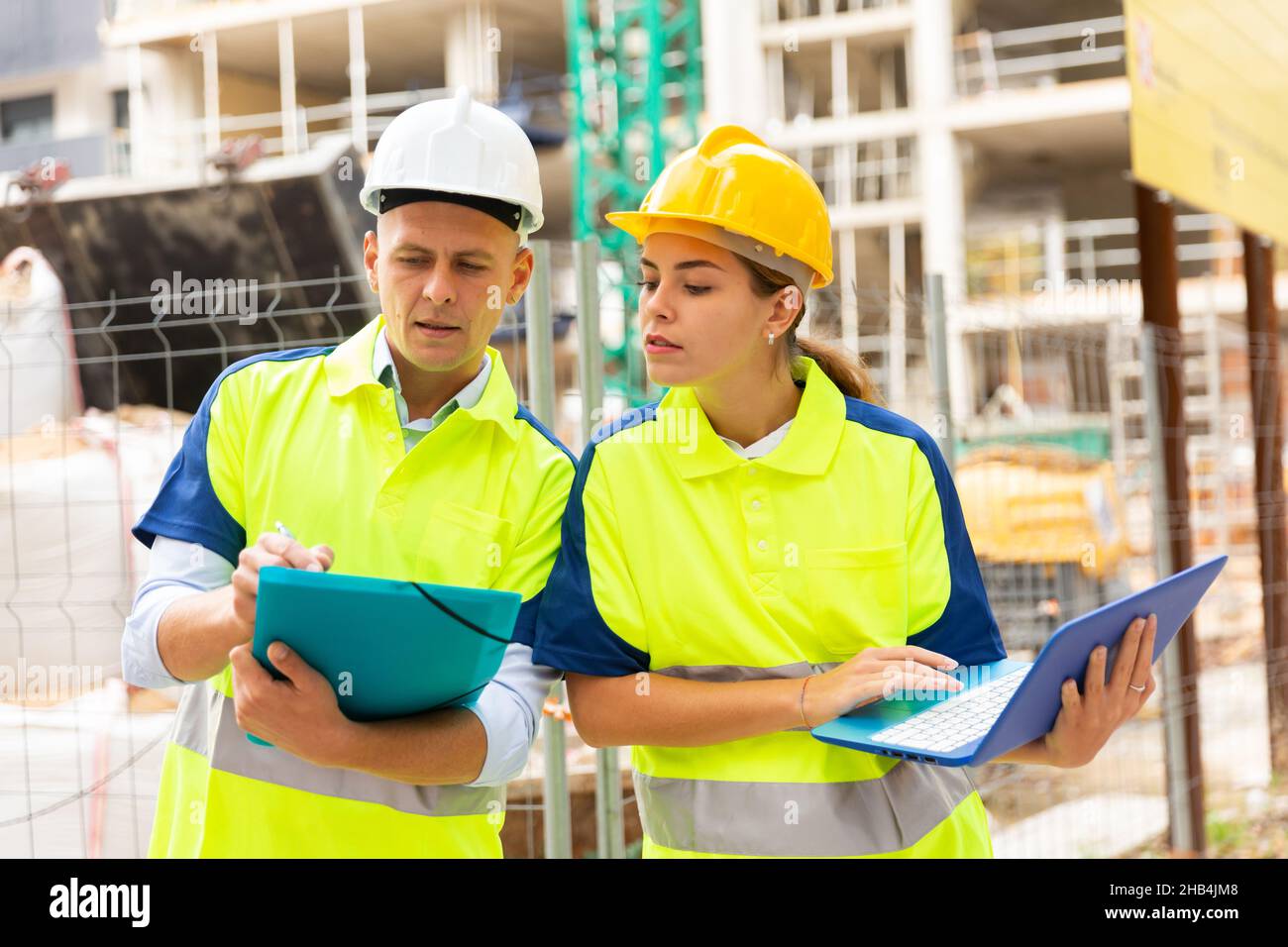Two builders planning their work in construction plant Stock Photo - Alamy