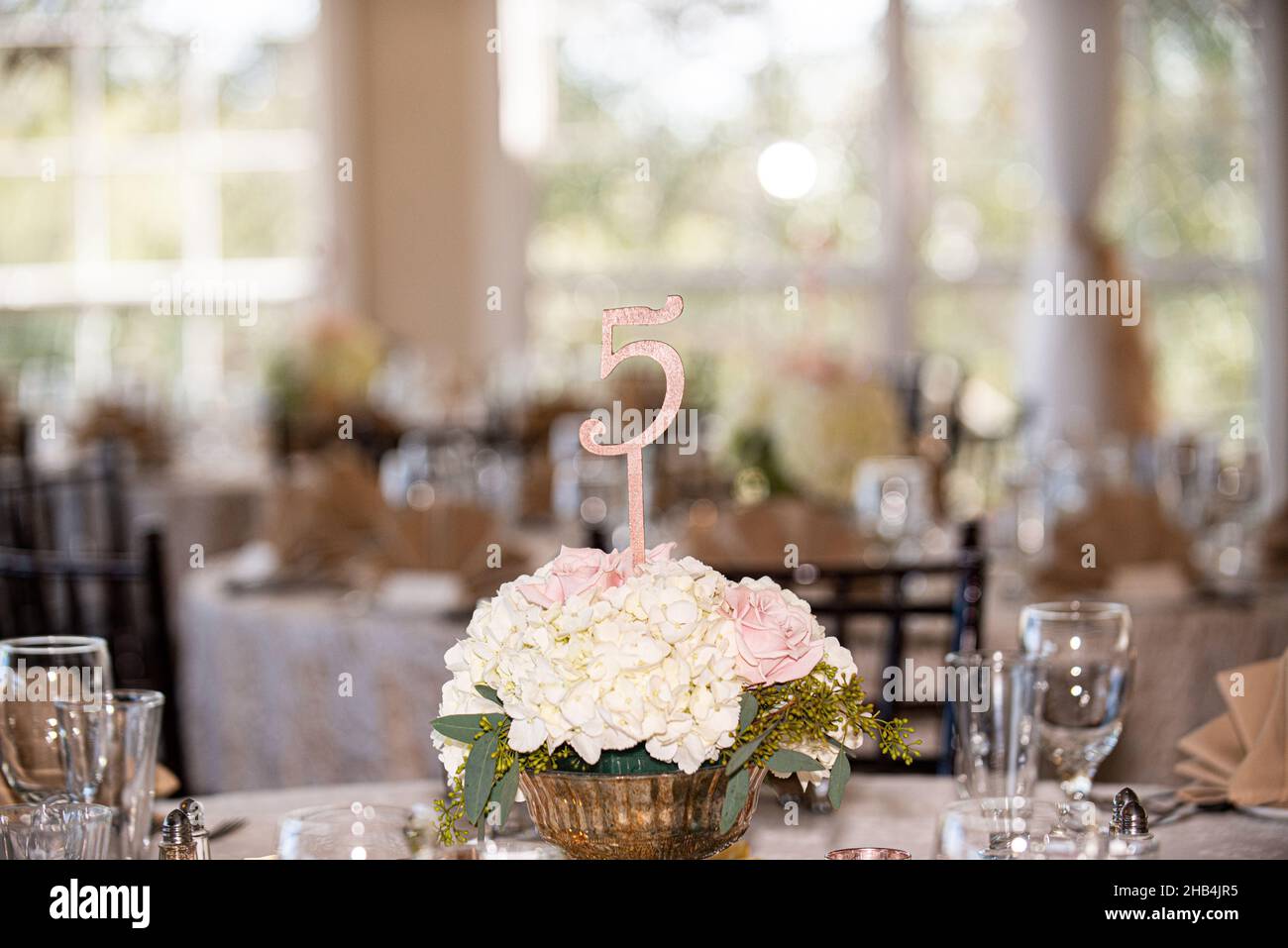 Pink number five guest place indicator sign in flowers at elegant ...