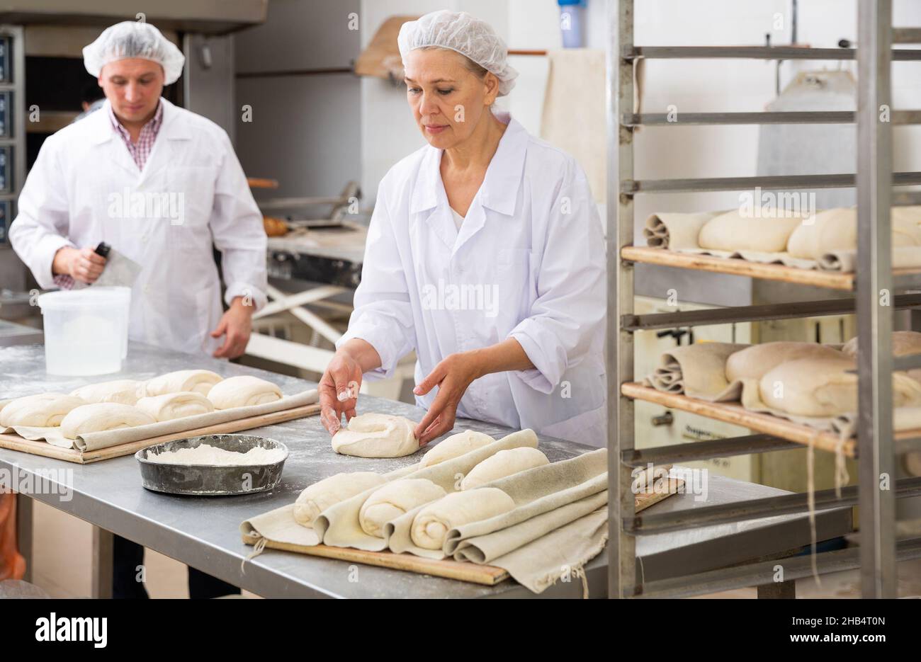Female baker prepares sweet pastries in the kitchen of bakery Stock ...