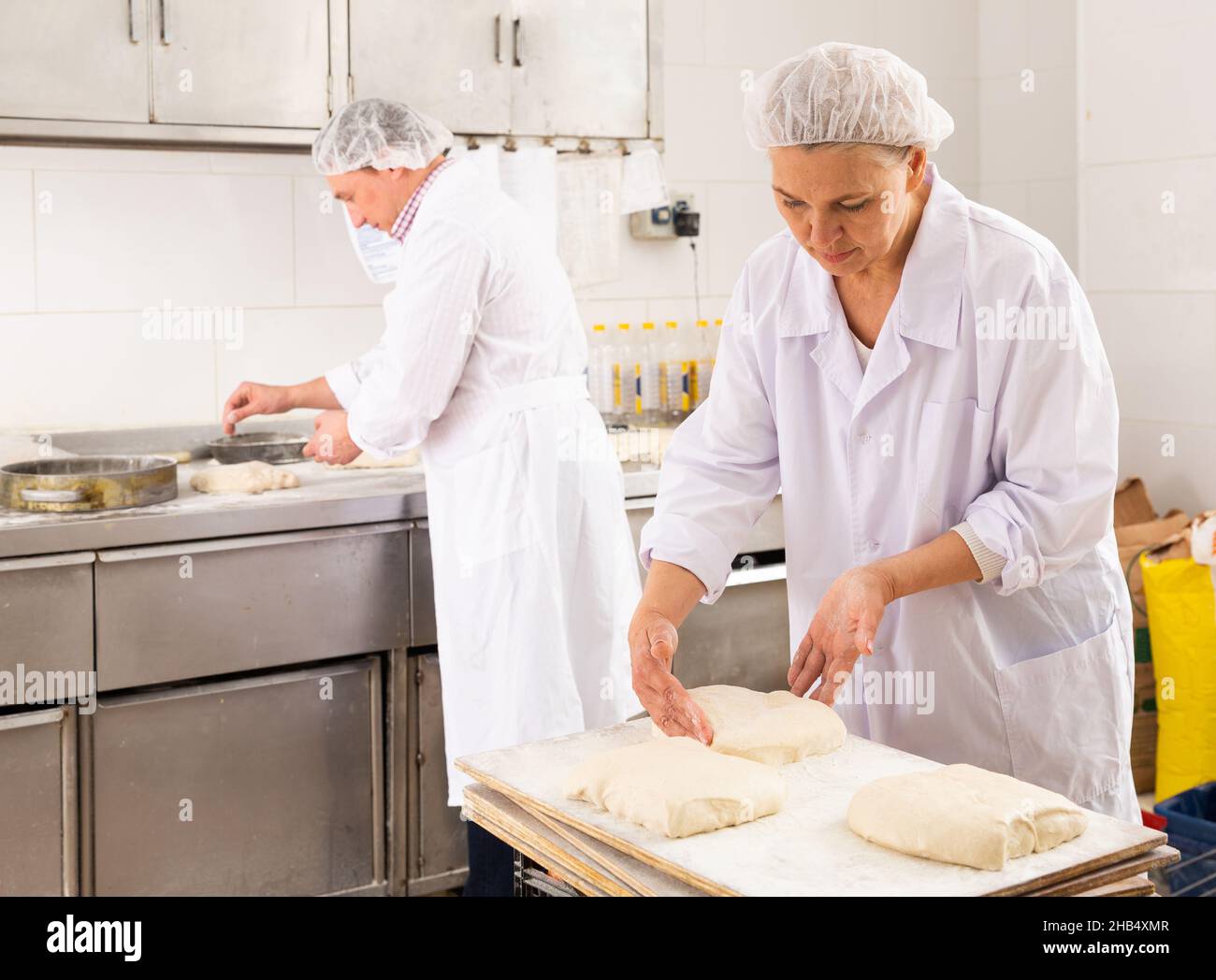 Female baker forming bread loaves from dough Stock Photo - Alamy