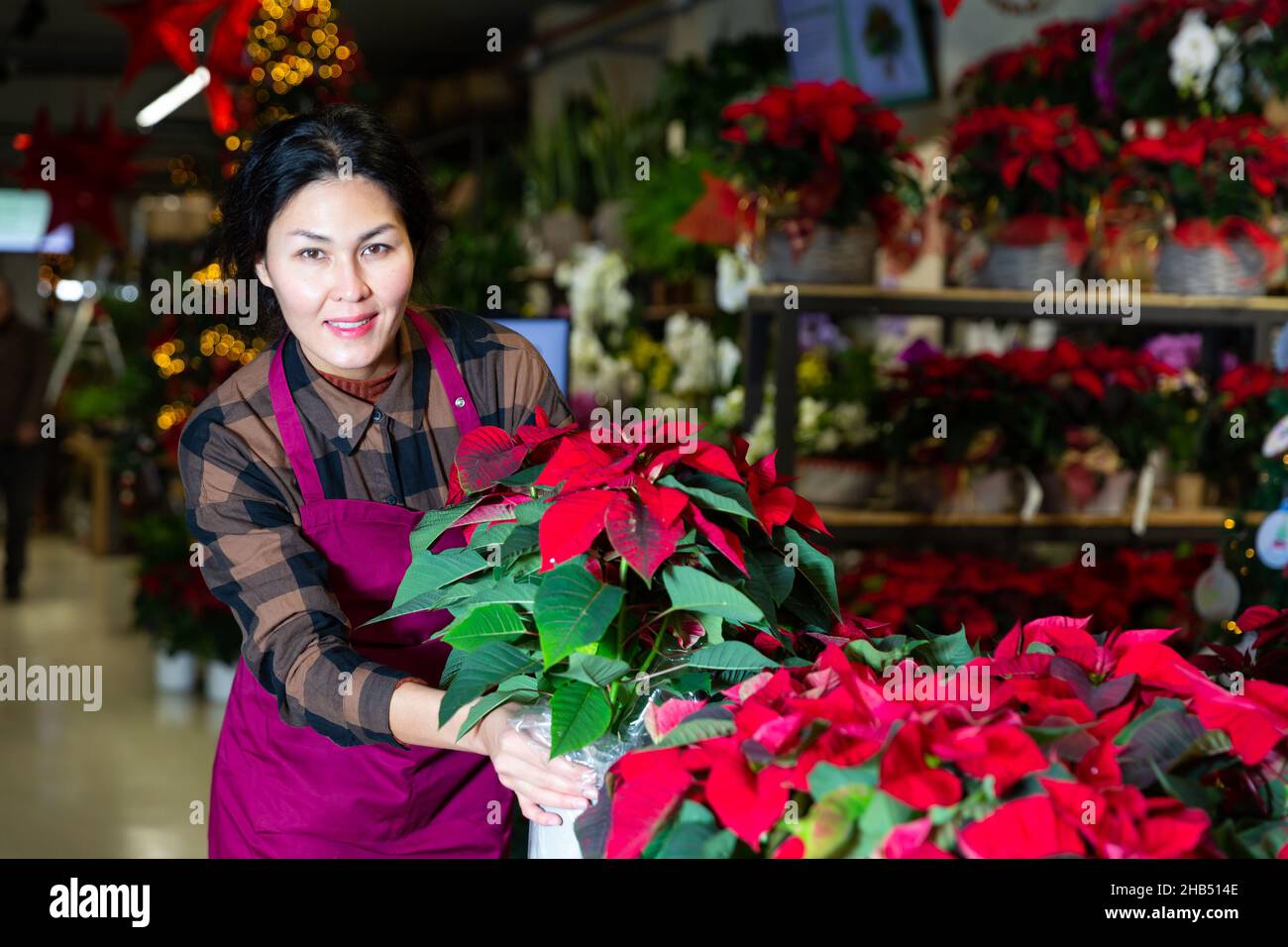Female home plants store worker carrying pot Stock Photo - Alamy