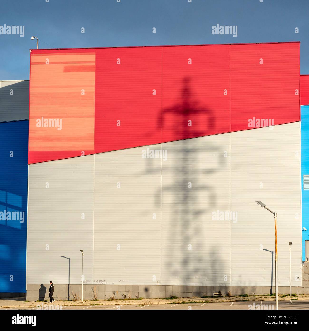 Lone man walking past colourful building in urban environment Stock ...