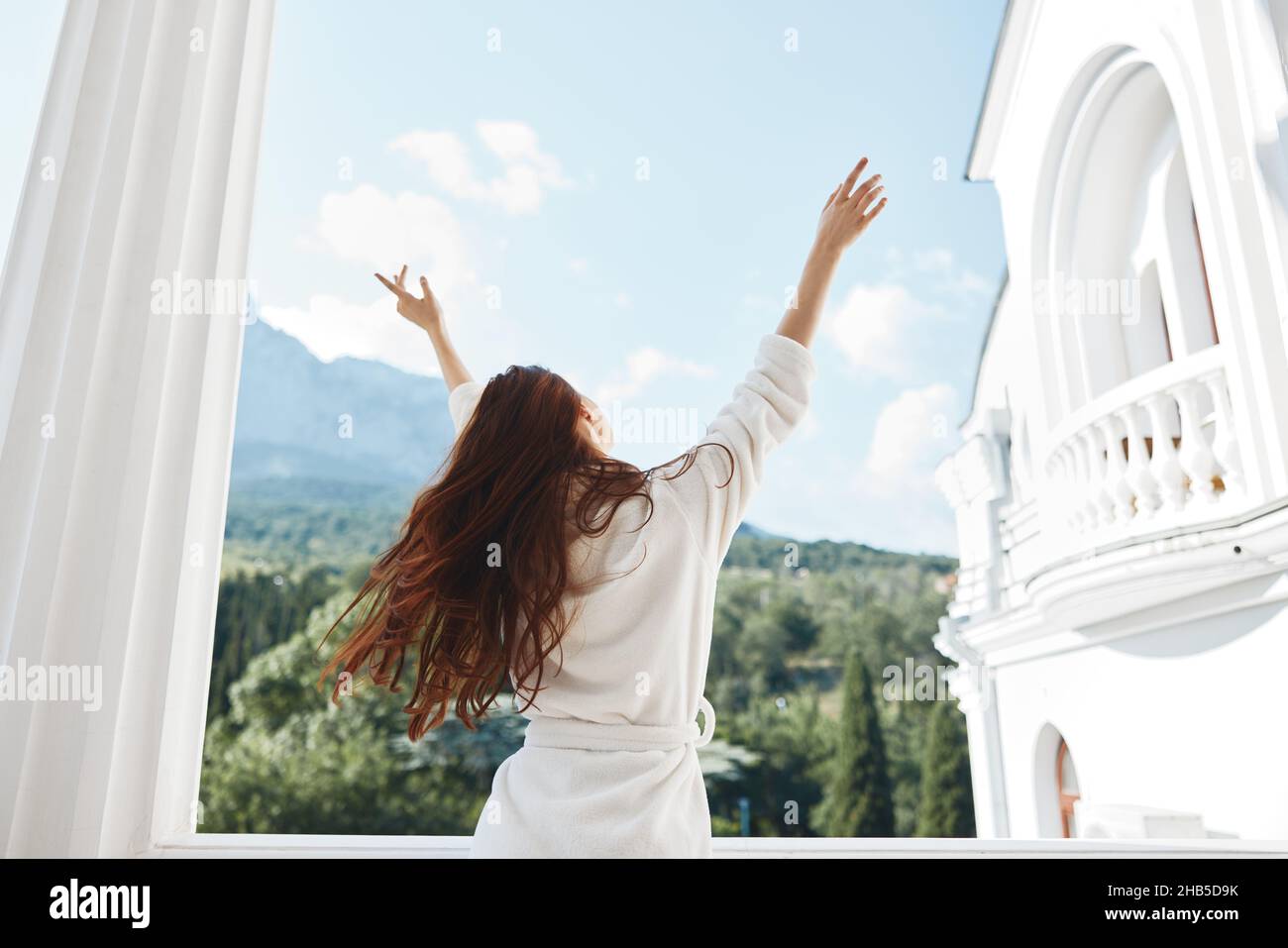 Attractive young woman hands up on the balcony Perfect sunny morning ...