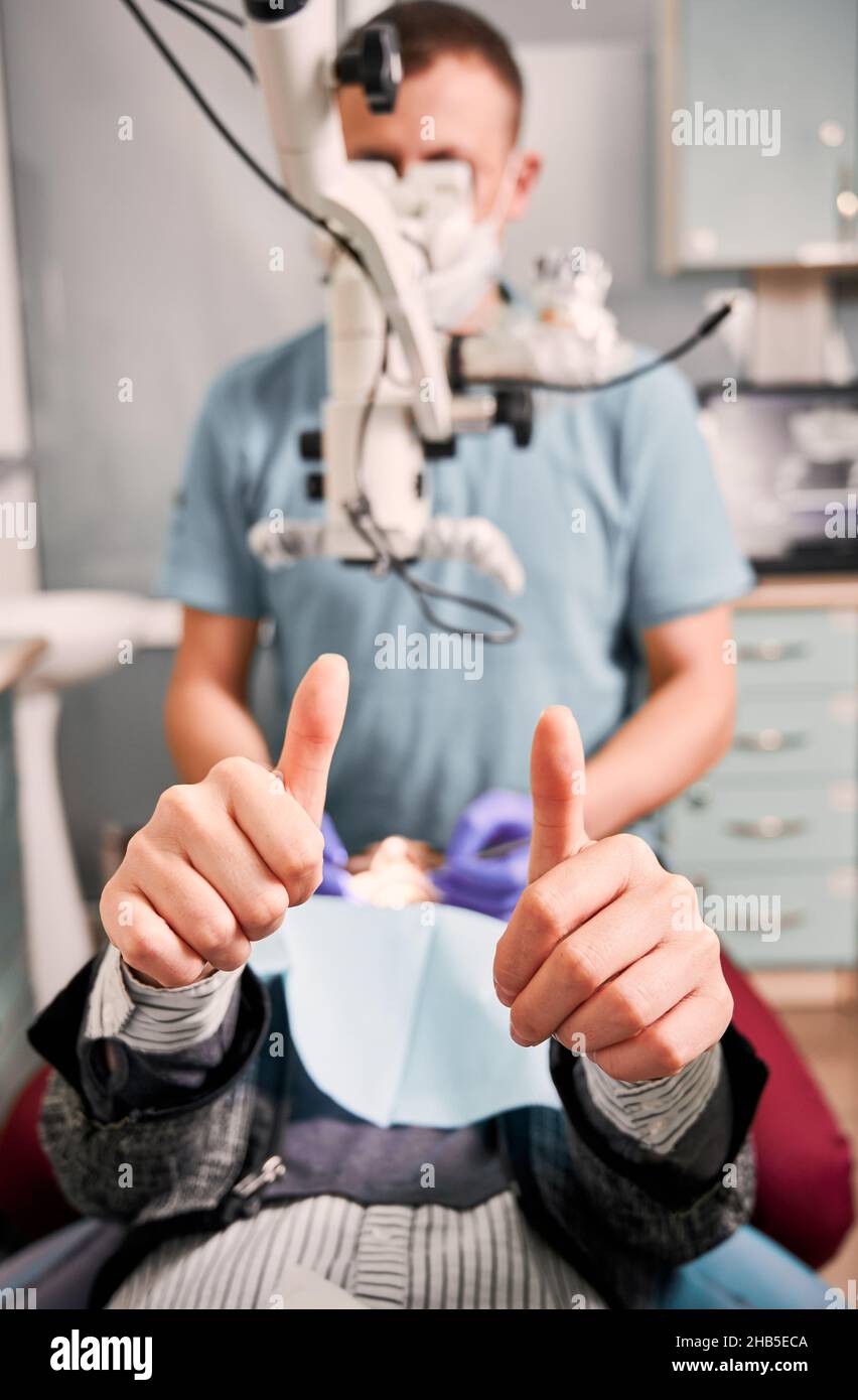 Close up of young woman showing approval gesture while lying in dental ...