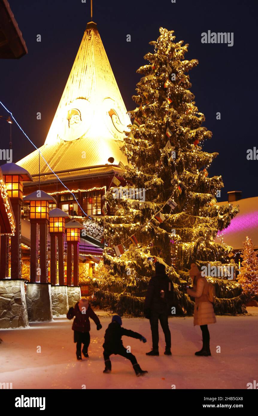 Children (front) play in front of a Christmas tree at Santa Claus ...