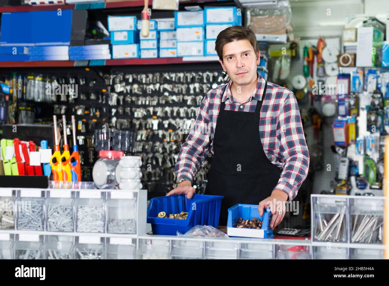 worker in hardware store trading goods for water tap in uniform Stock ...