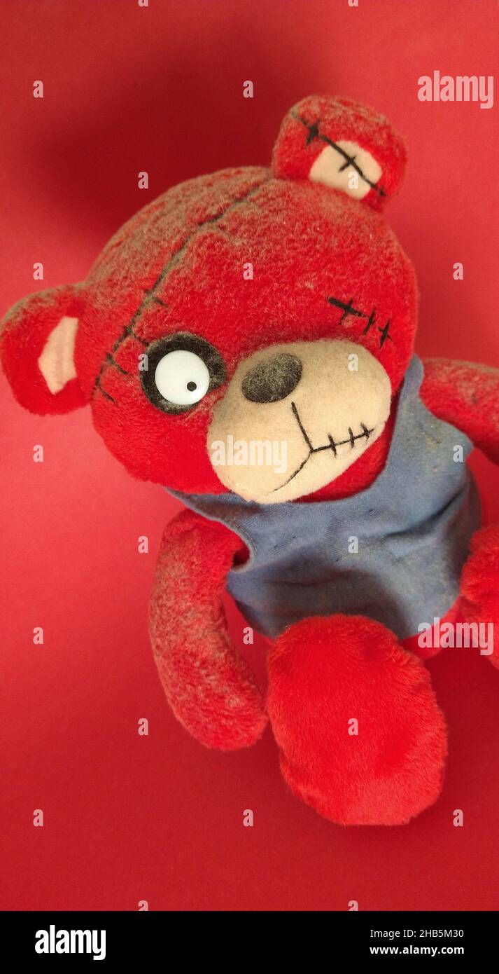 Scary red soft bear toy with one eye in a red background Stock Photo ...