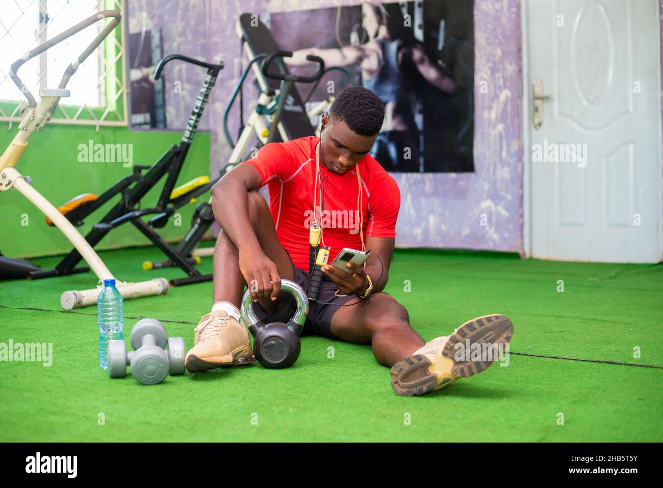 Black bodybuilder using mobile phone at gym Stock Photo - Alamy