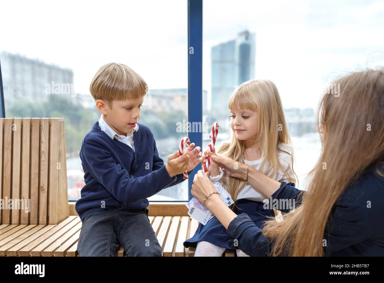 mom gives children candy canes Stock Photo - Alamy