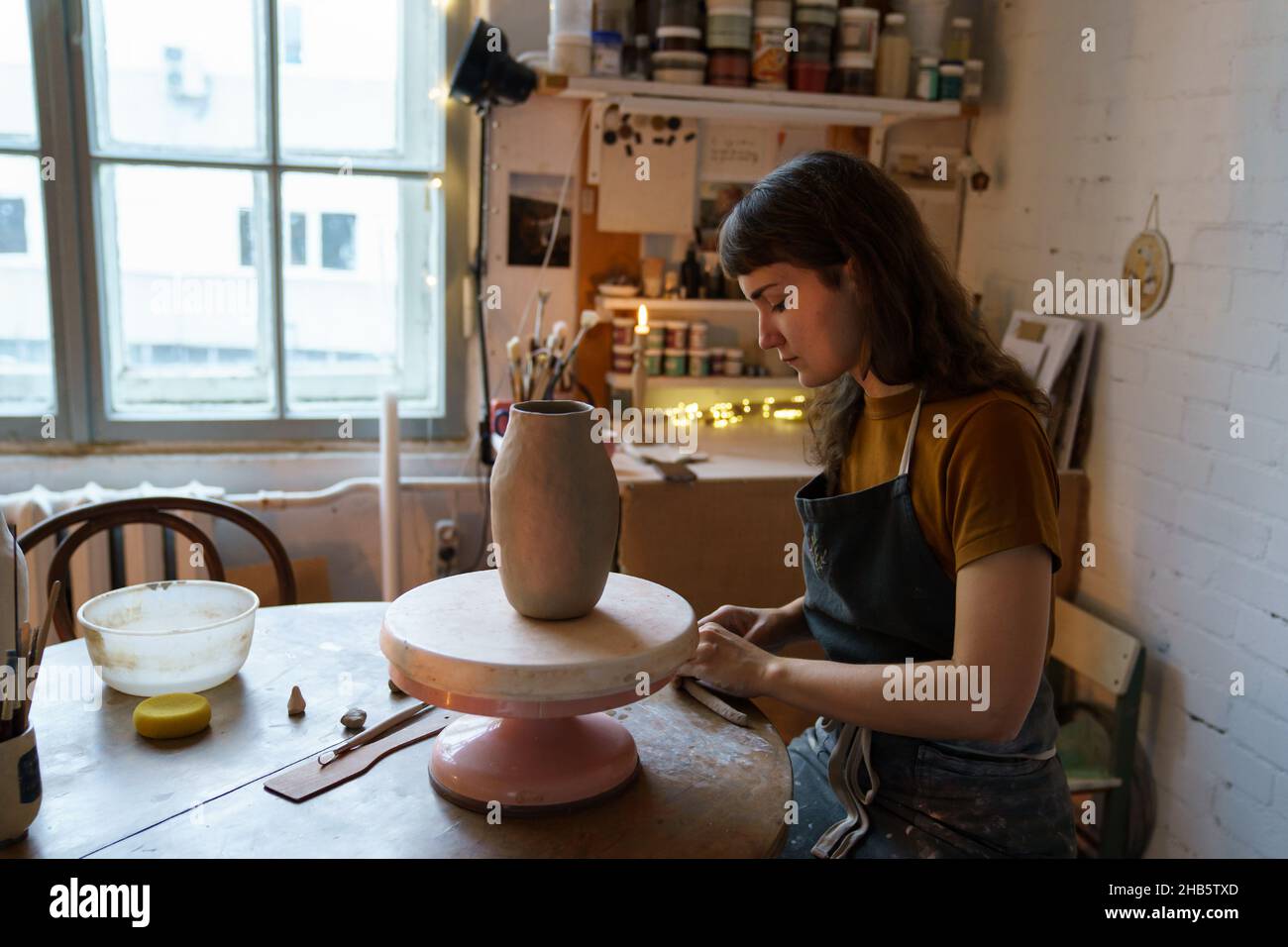 Creative woman shaping vase of clay at classes in art studio. Female ...