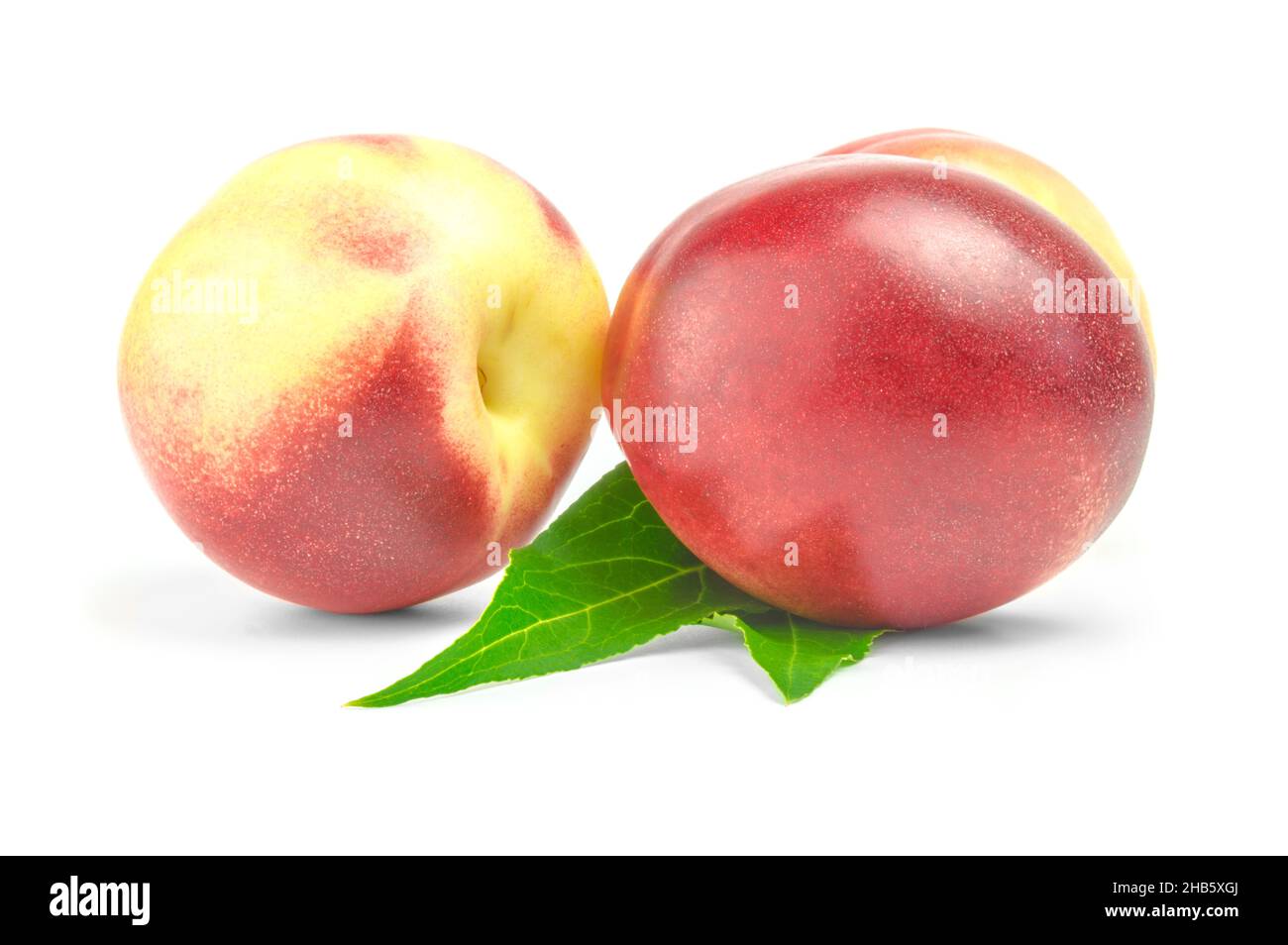 Two ripe nectarines with green leaves over white background Stock Photo ...