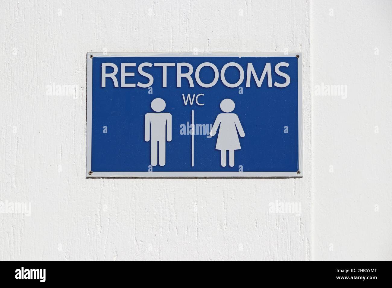 Blue Restrooms (toilets) sign on white wall Stock Photo - Alamy