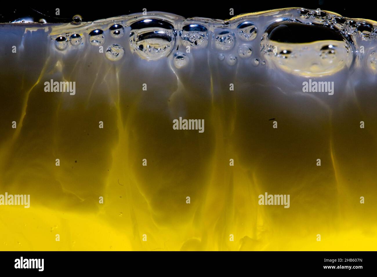Yellow liquid with bubbles Stock Photo - Alamy