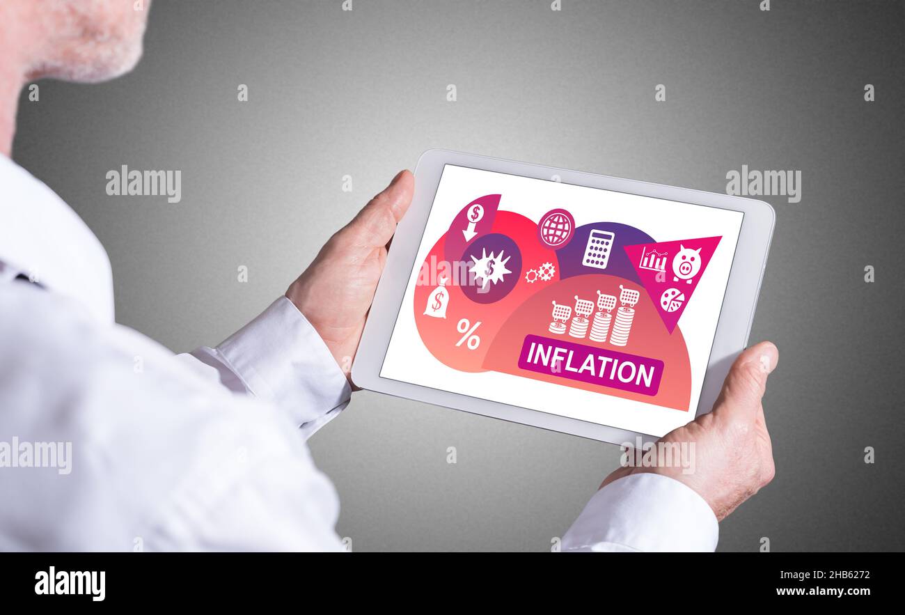 Man holding a tablet showing inflation concept Stock Photo - Alamy