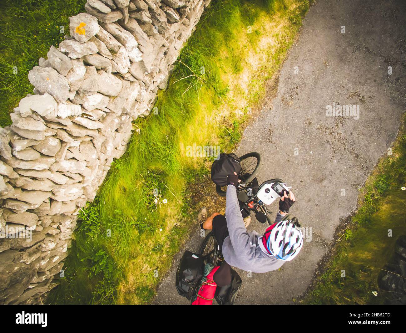 Cyclist is standing with bicycle and controlling drone with remote ...