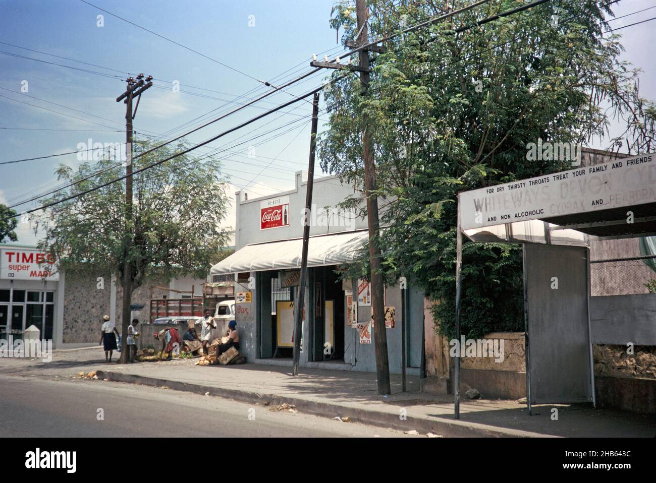 Street scene shops, bar, bus shelter with advertising for Whiteways ...