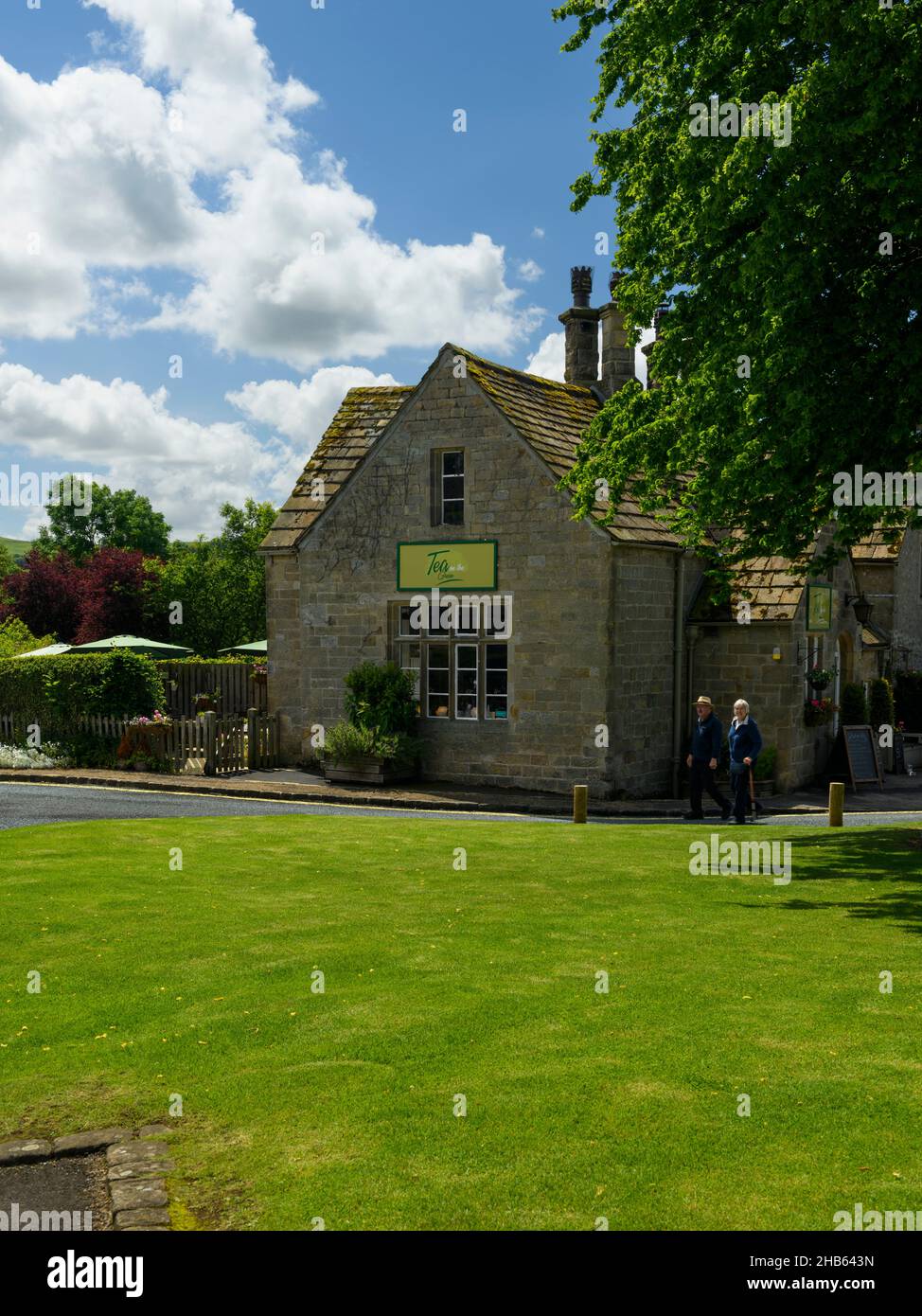 2 walkers in summer passing quaint attractive cottage tea rooms cafe ...