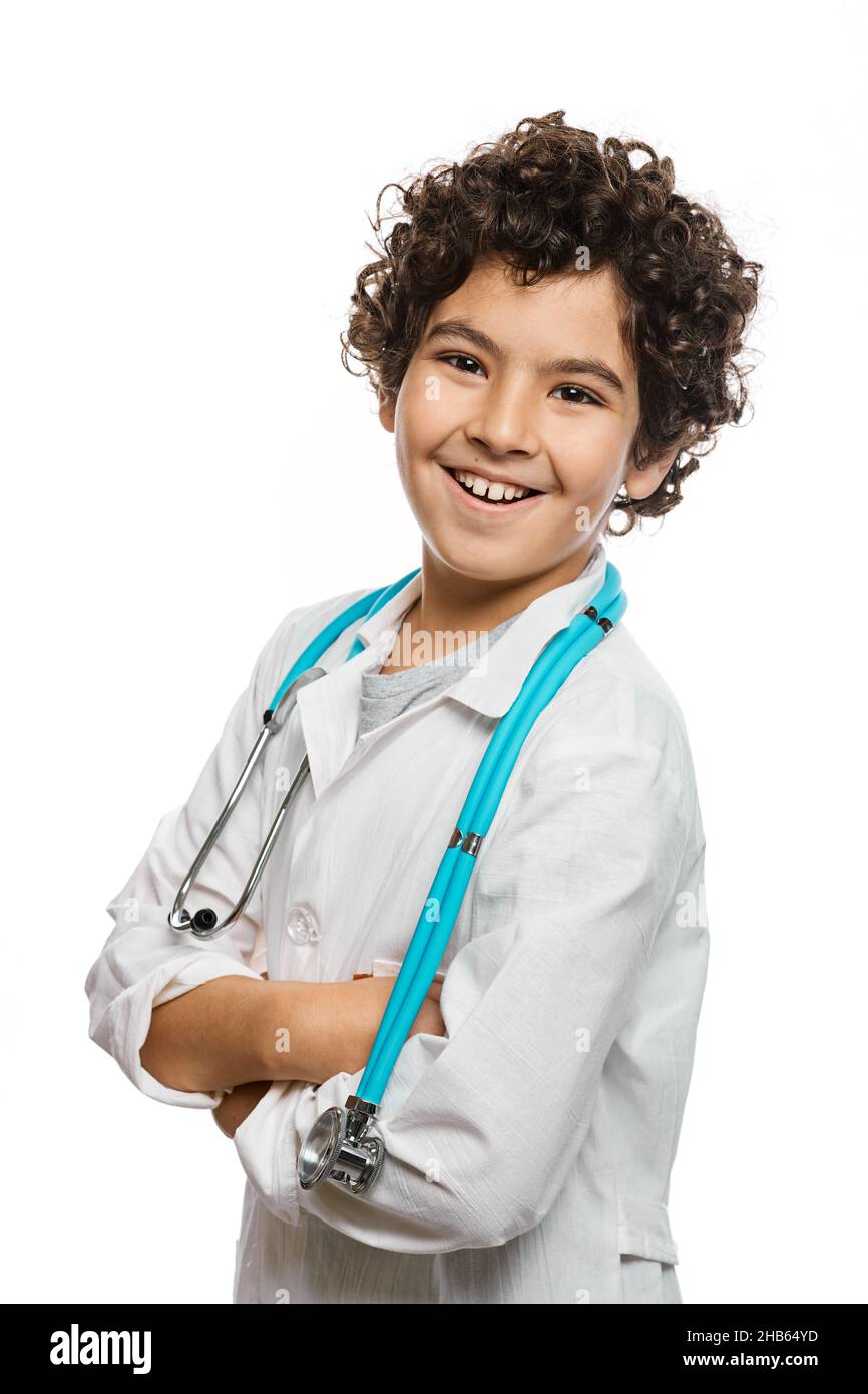 Smiling cute boy wearing a doctor's coat with arm crossed, posing and ...