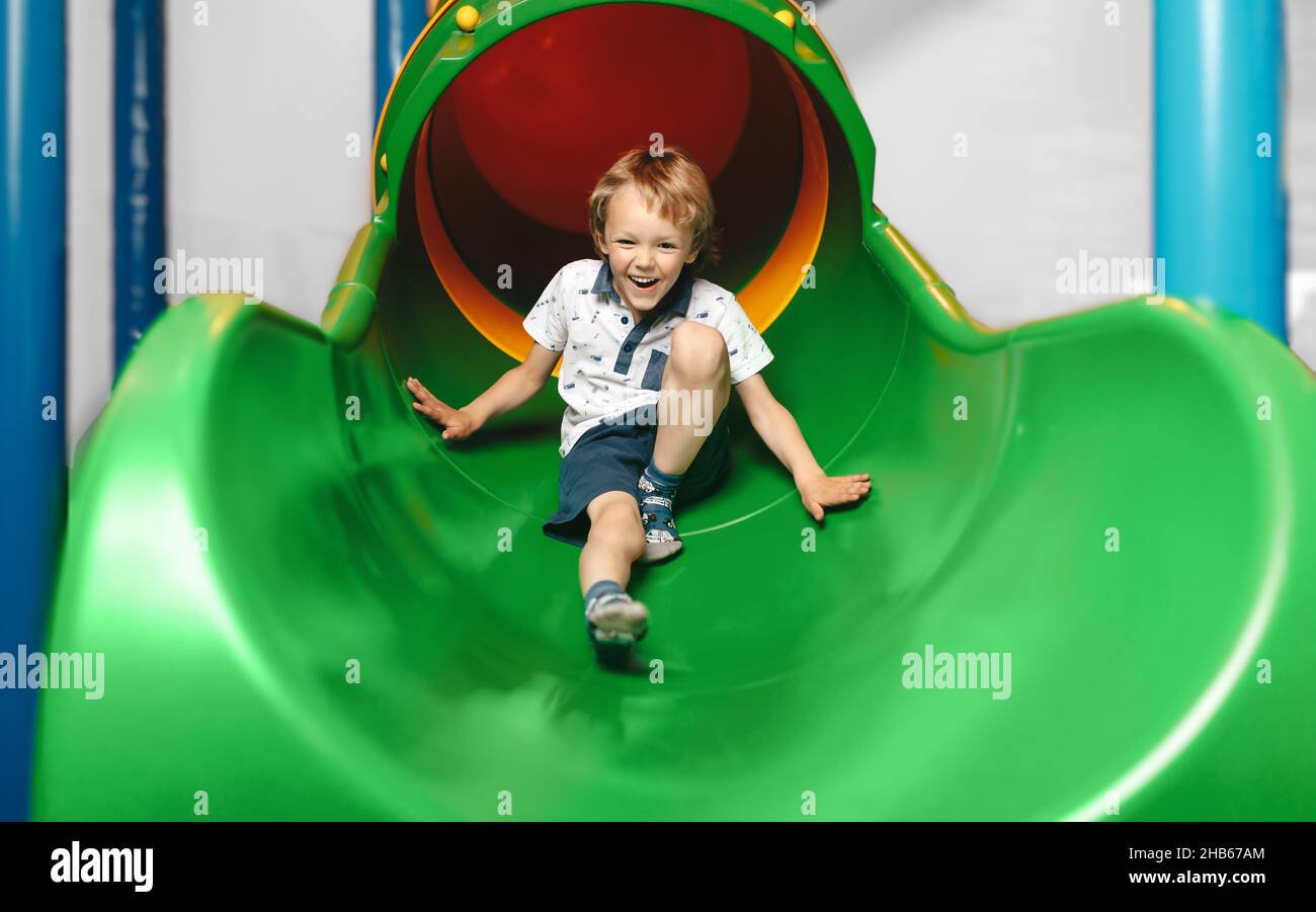 Happy Kid Sliding Fast In Tube Slide On Playground Park. Joyful Boy ...