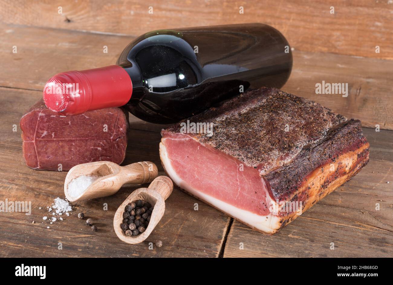 Smoked meats with a bottle of wine on wooden background Stock Photo - Alamy