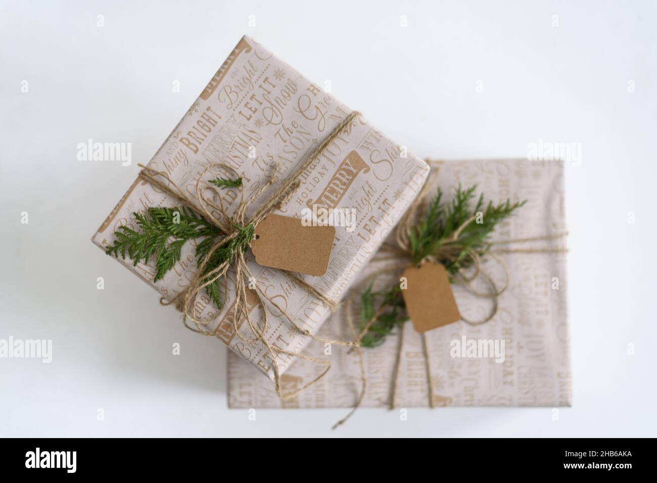 Wrapped in craft paper gift boxes with empty tag on light grey ...
