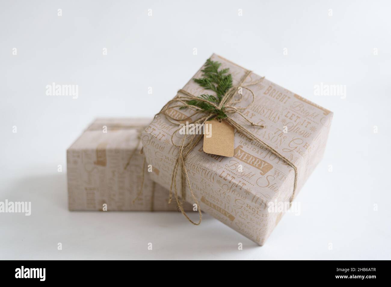 Wrapped in craft paper gift boxes with empty tag on light grey ...