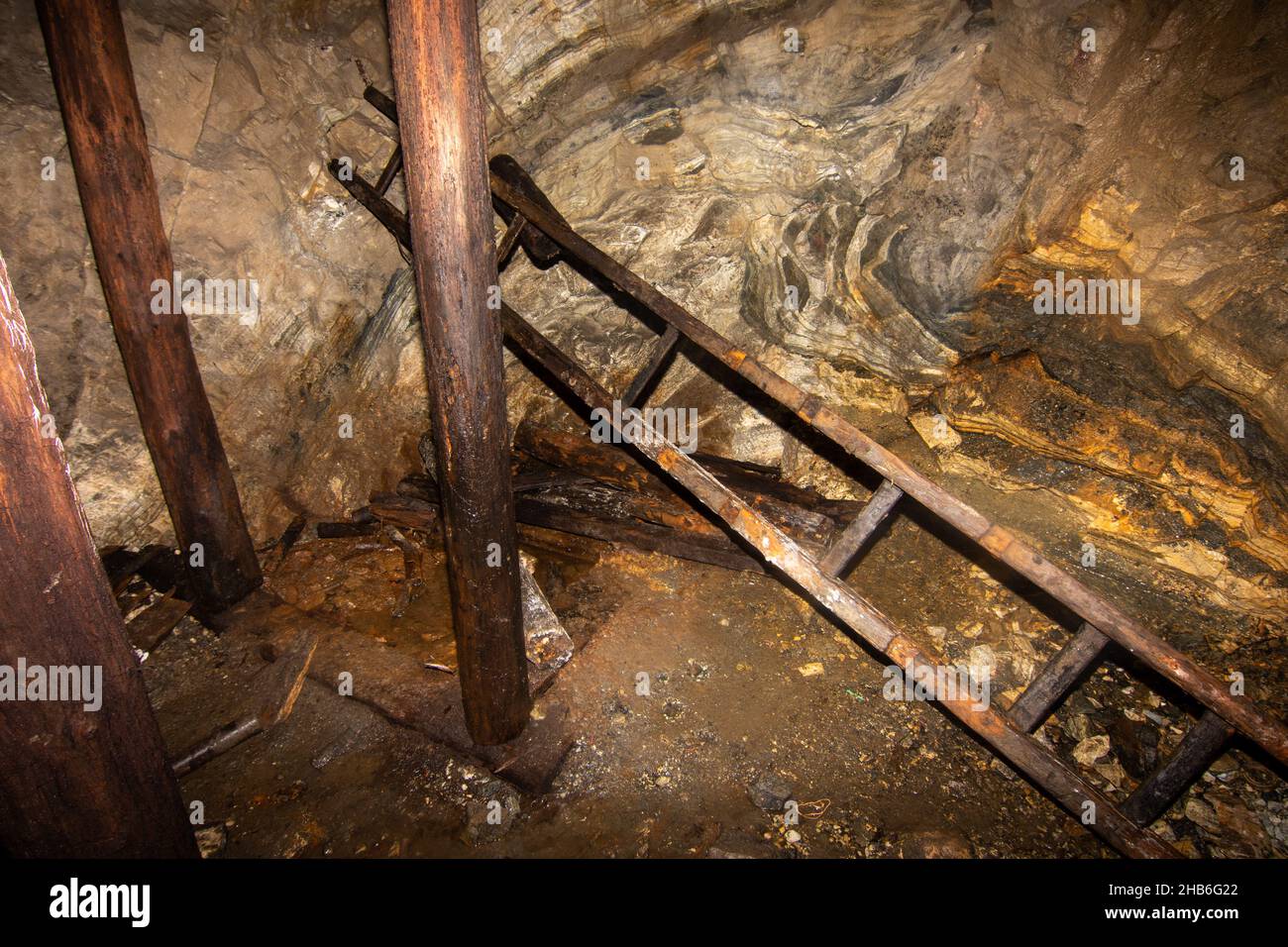 Old abandoned coal mine tunnel underground with wooden timbering and ...