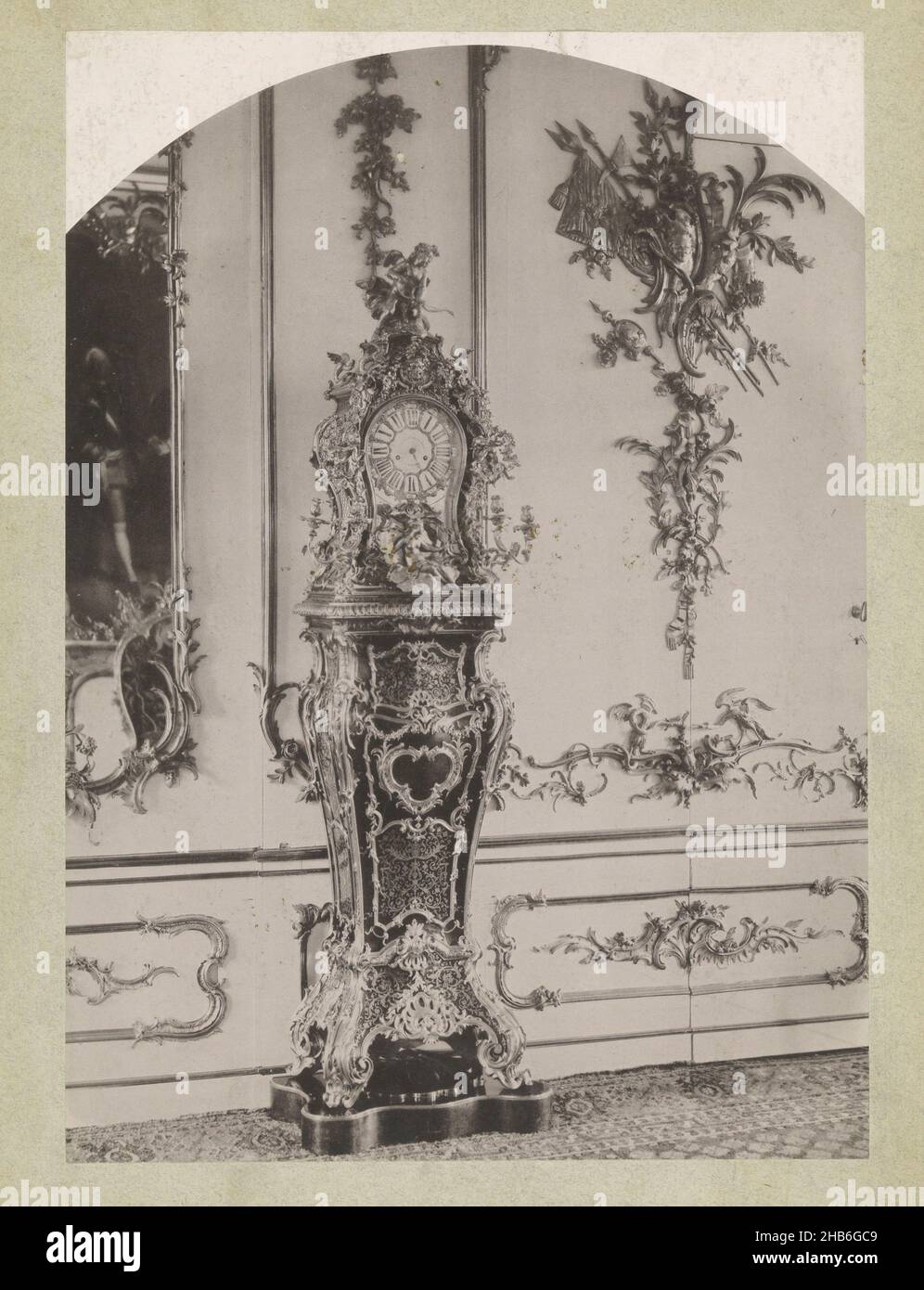 Standing clock decorated with plant motifs, a putti and a goddess ...