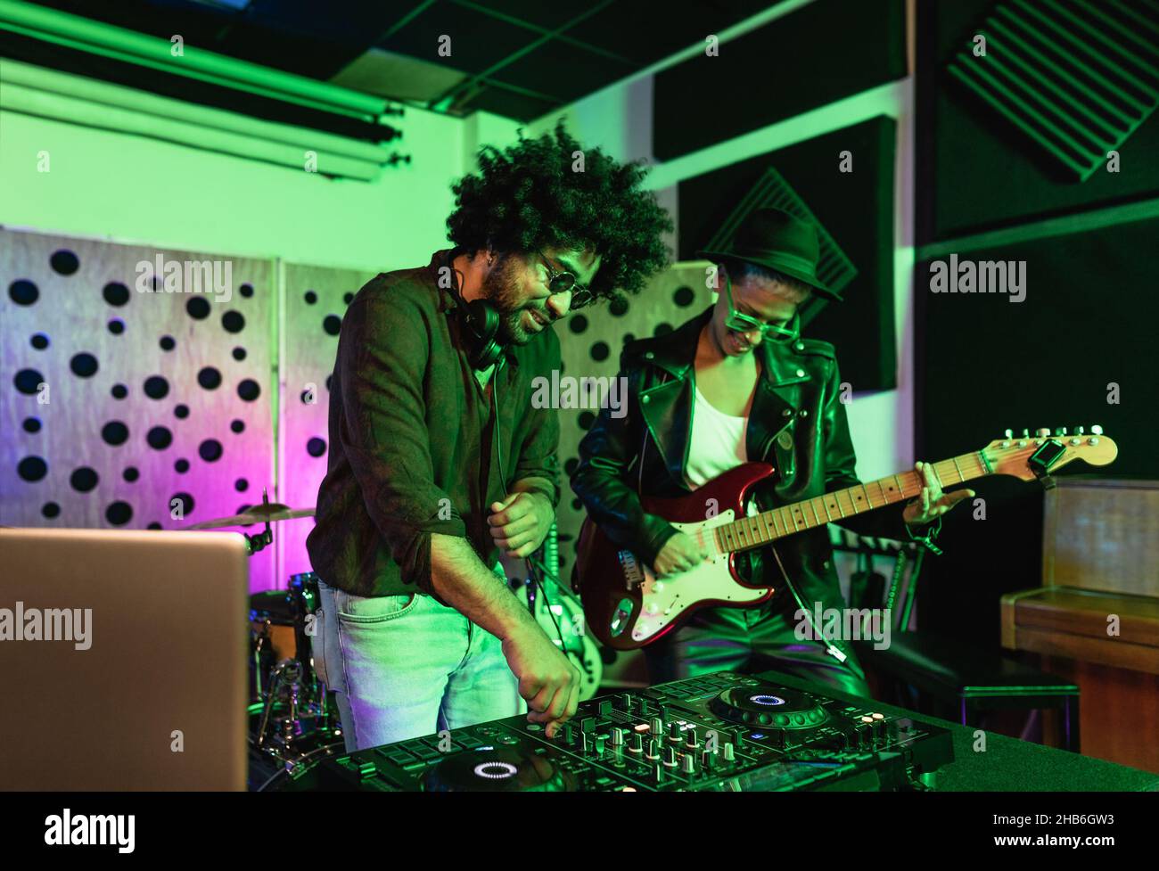 Young happy people playing music with dj mixer and guitar in house ...