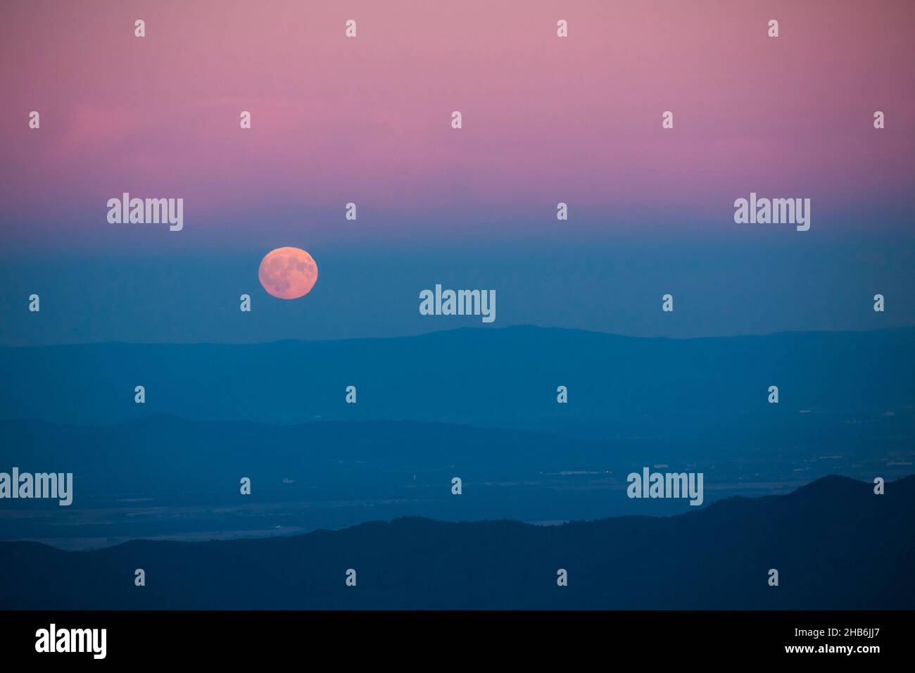 Mountain scenery of the Vosges with morning mist and pink full moon ...