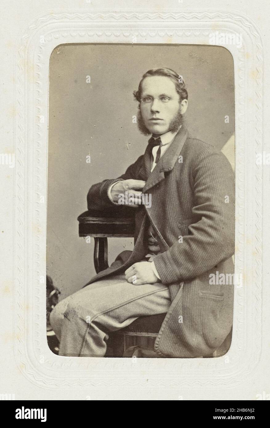 Studio portrait of a seated man with glasses and sideburns, Louis ...